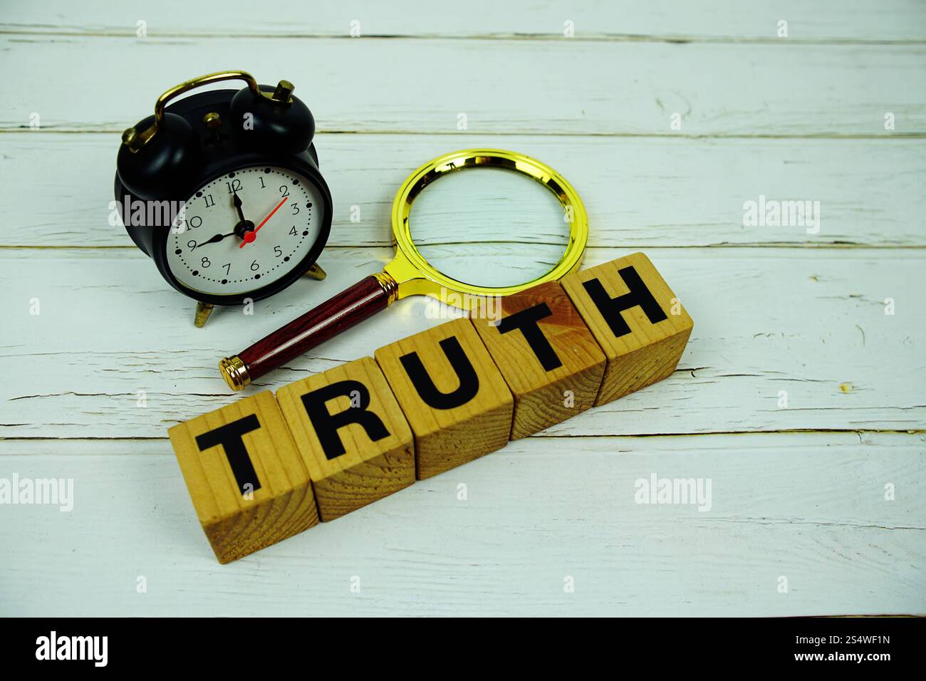 Truth alphabet letters with magnifying glass and alarm clcok top view ...