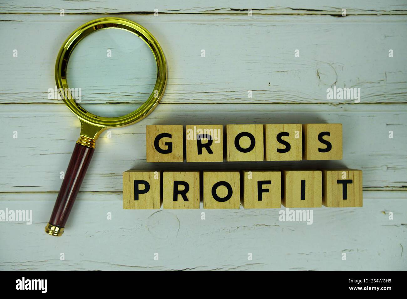 Gross Profit with wooden blocks alphabet letters and magnifying glass ...