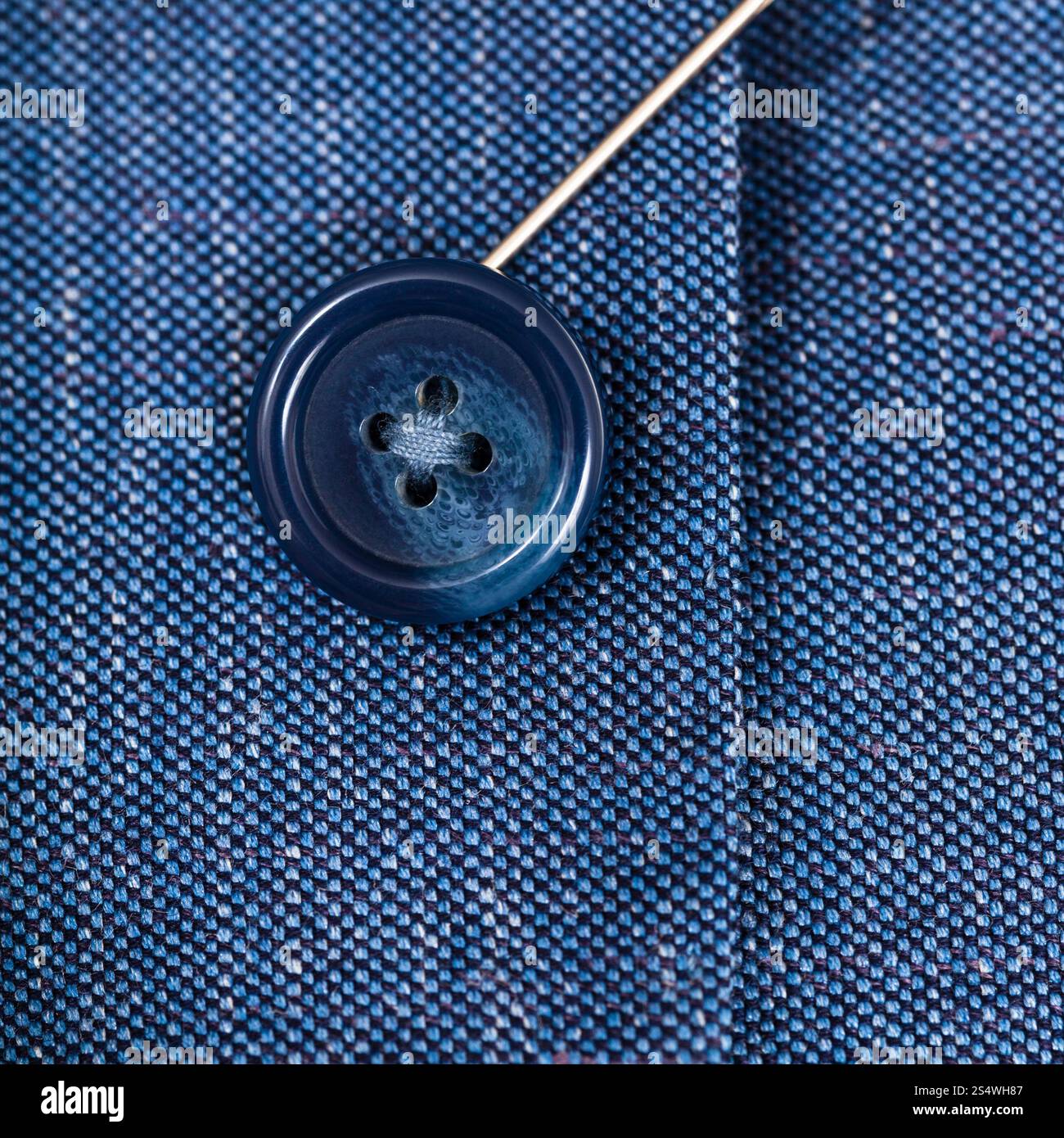 attaching of button to blue silk cloth by needle close up Stock Photo ...