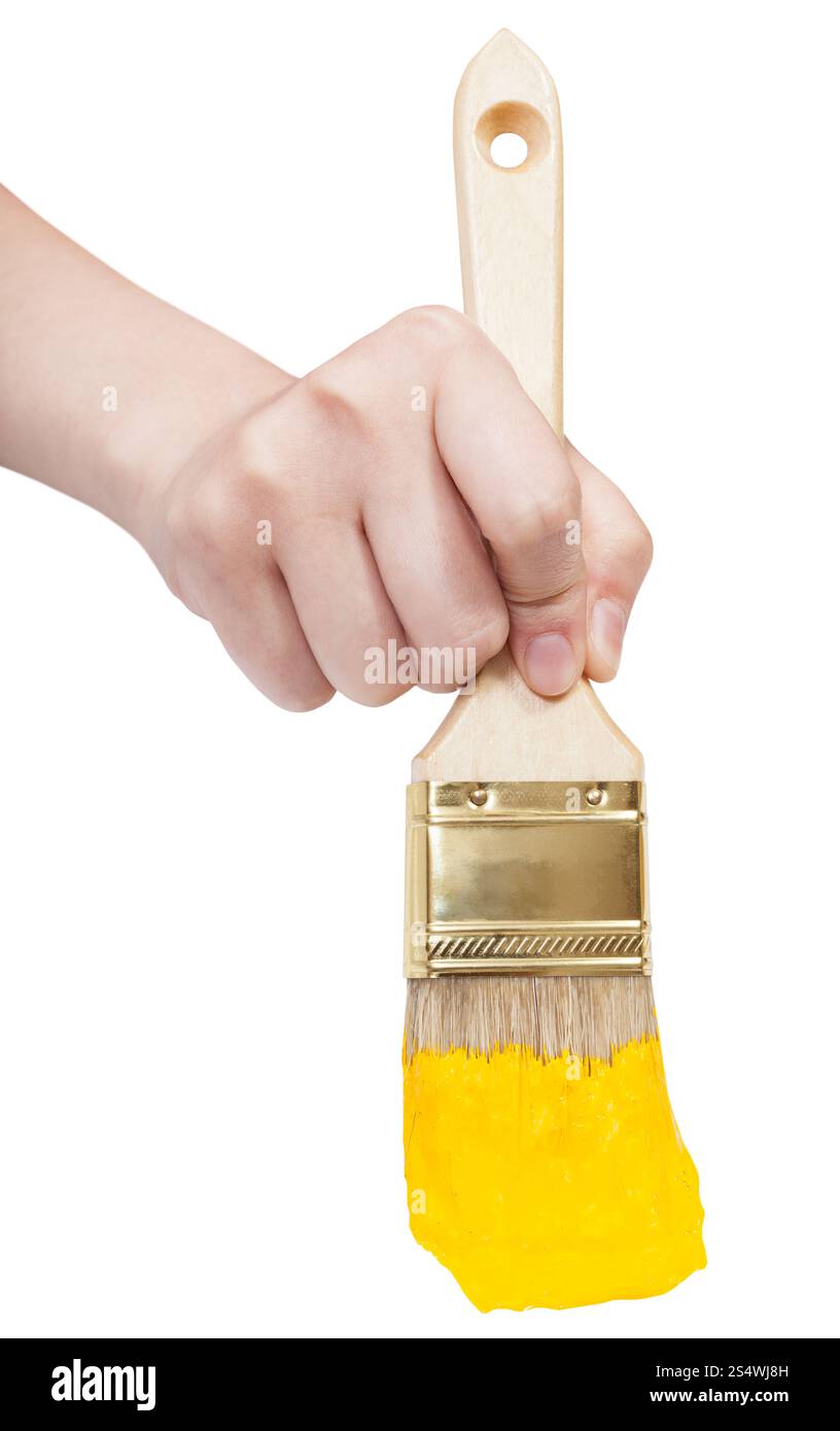 front view of painter hand with flat paintbrush painting in yellow ...
