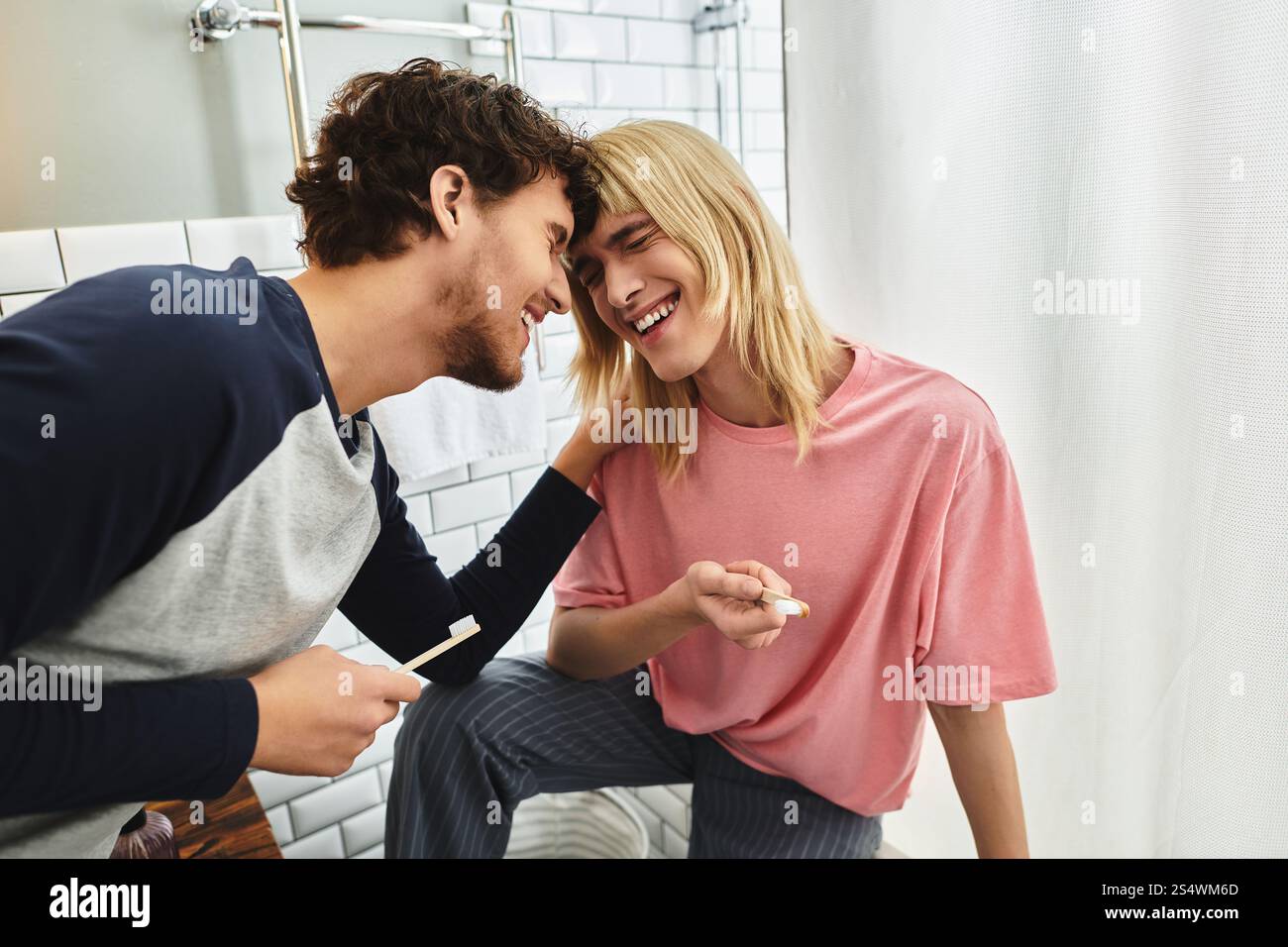 Two loving men smile at each other while enjoying their morning routine ...