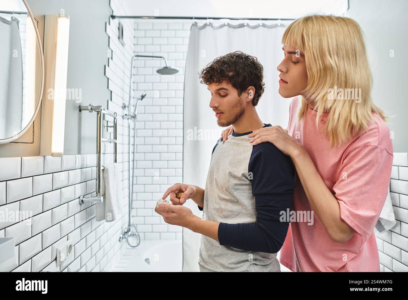 Two men enjoy each others presence while preparing for the day in a bright bathroom Stock Photo ...