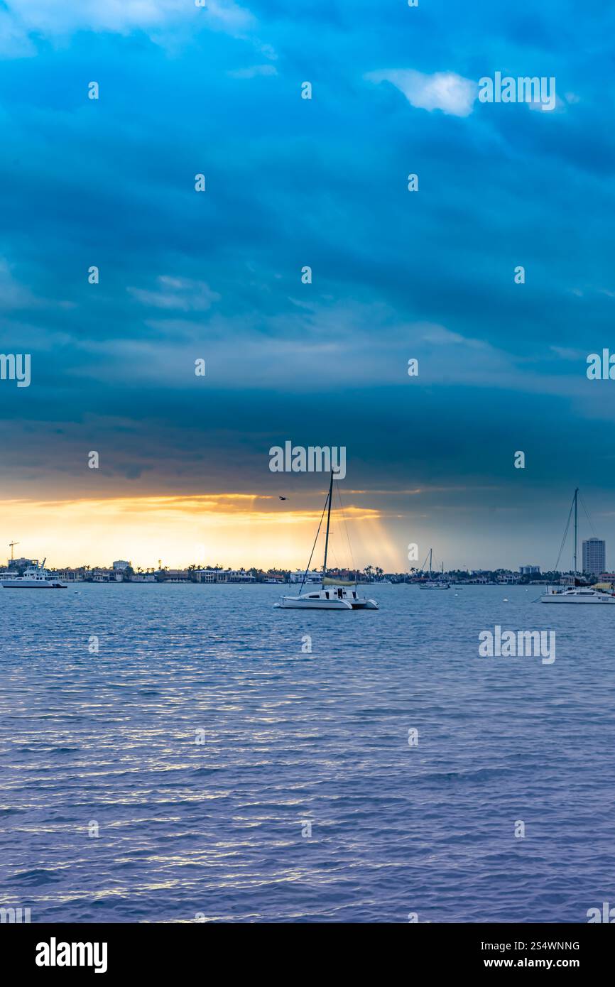 A beautiful sunset at Bayfront Park, Sarasota, Florida, features a vibrant sky with blue, puffy ...