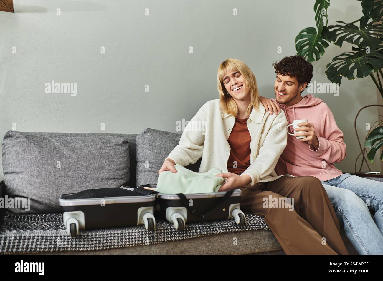 Two men share a warm and loving moment while packing their bags ...