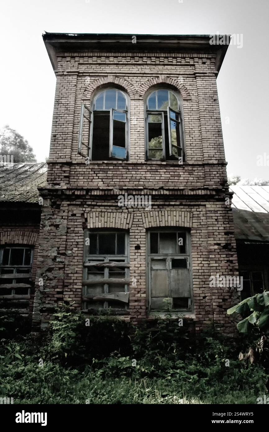 Old deteriorated brick building with shattered windows and dense ...