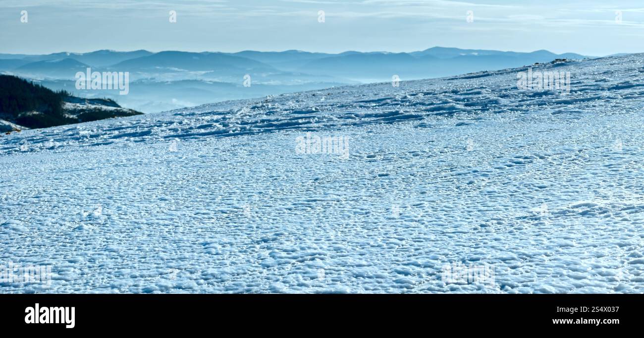 Wind form ice texture on winter mountain snow surface in contra light ...