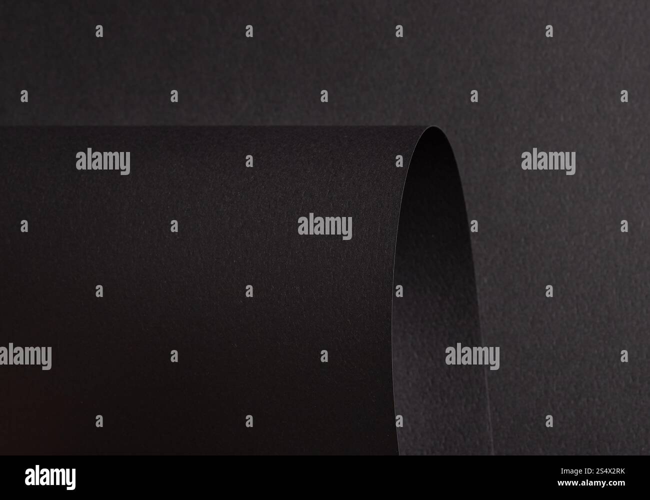 Charcoal black paper background with curved, matte surfaces and a ...