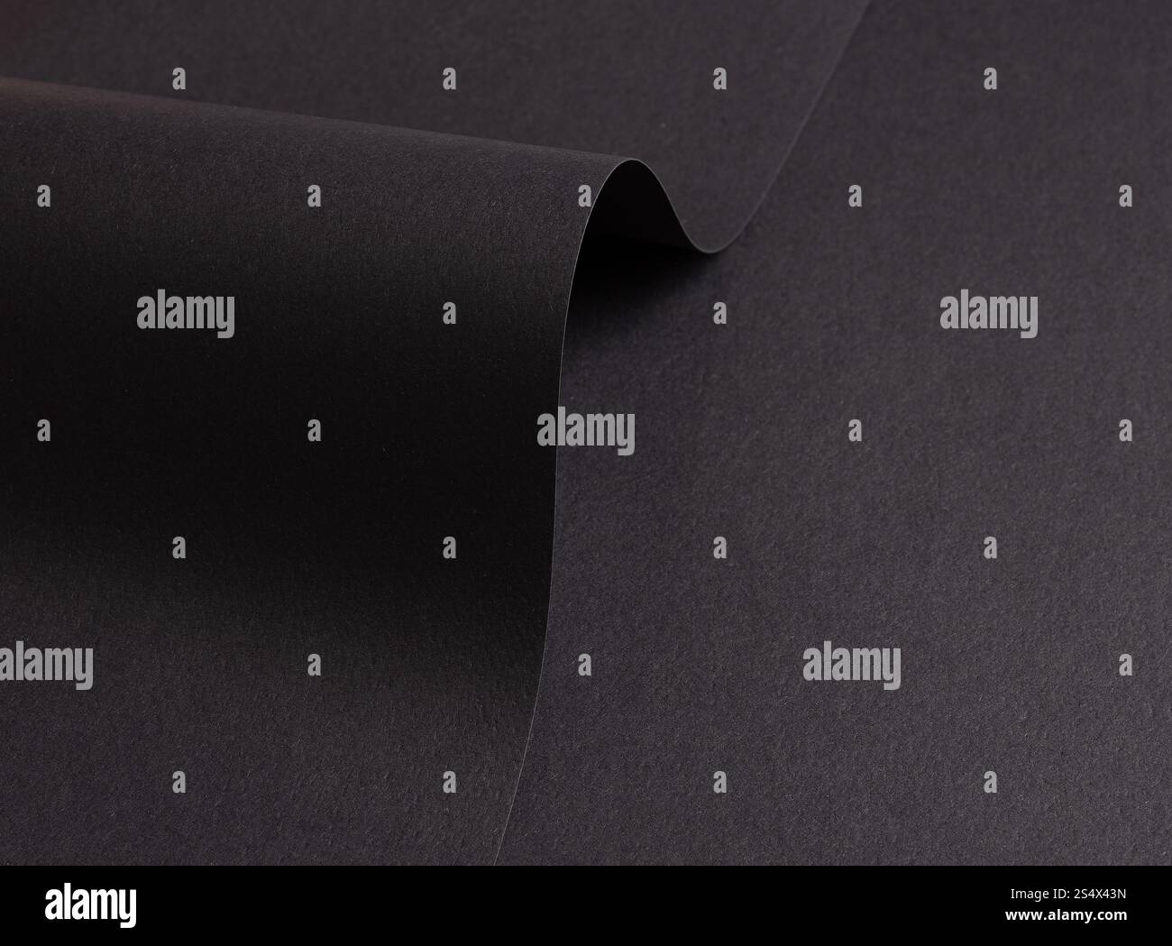 Charcoal gray paper background with folded, curved matte surfaces ...