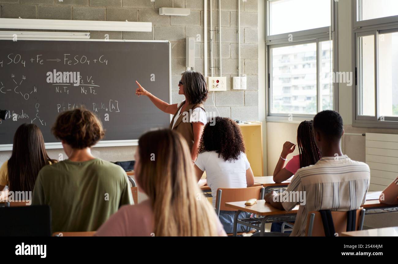 Teacher Explaining Chemistry Formulas to Students in a Classroom ...