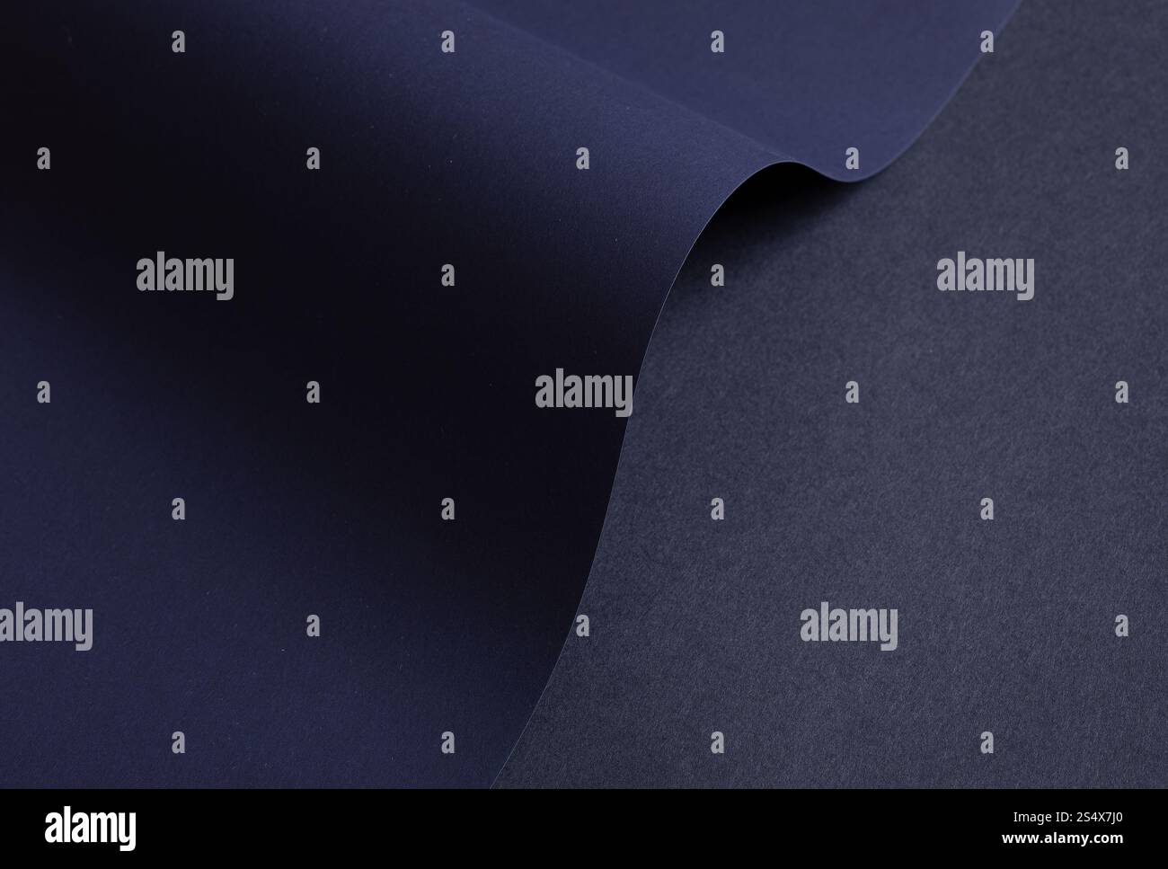 Midnight blue paper background with curved, matte surfaces and a smooth ...