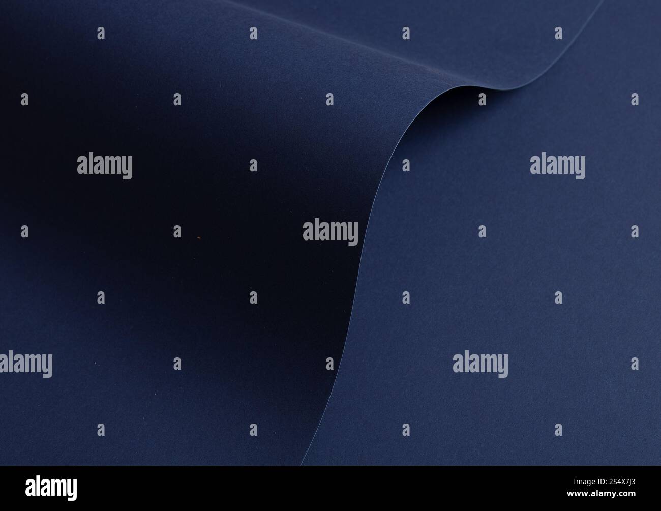 Midnight blue paper background with curved, matte surfaces and a smooth ...