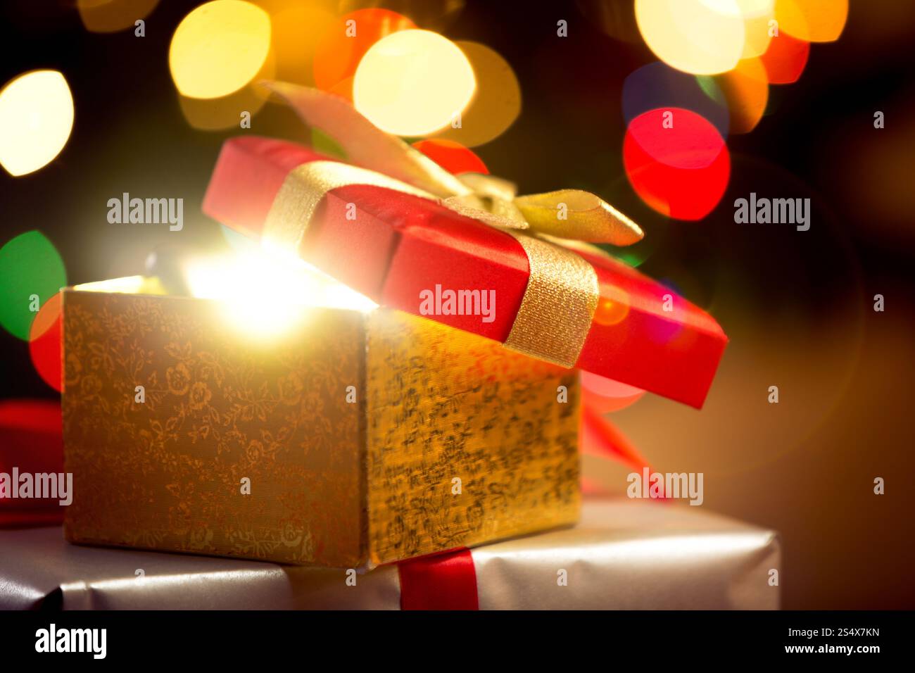 Closeup photo of open Christmas gift box on glowing lights background ...