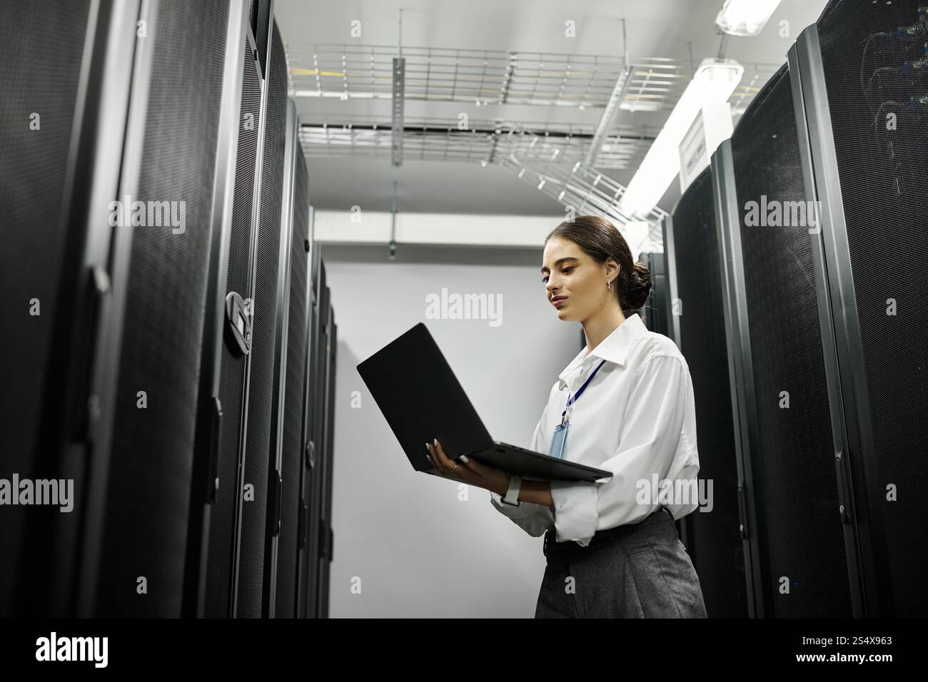 Woman in a white shirt works diligently in a modern server room ...