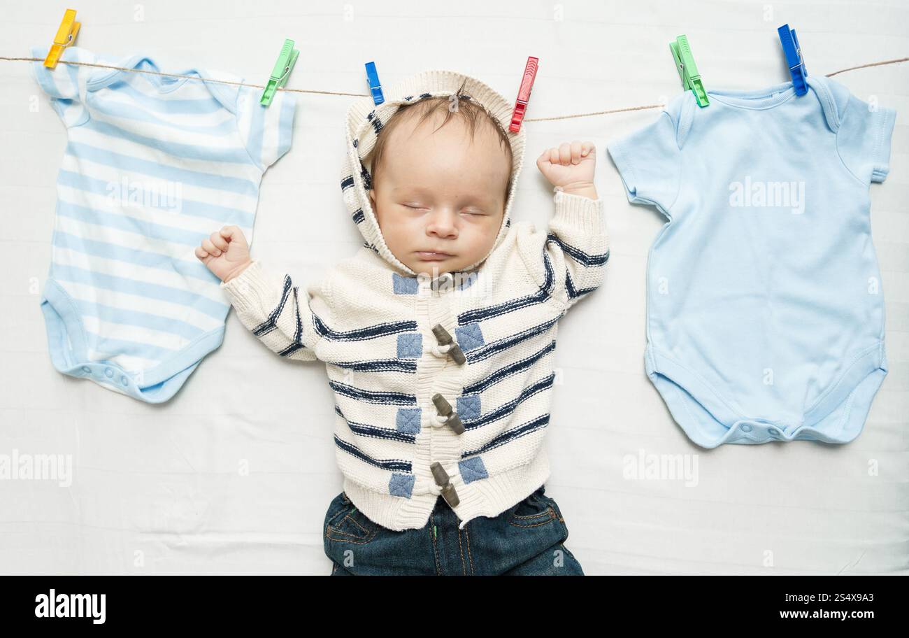 Funny photo of cute baby boy hanging on clothesline next to drying ...