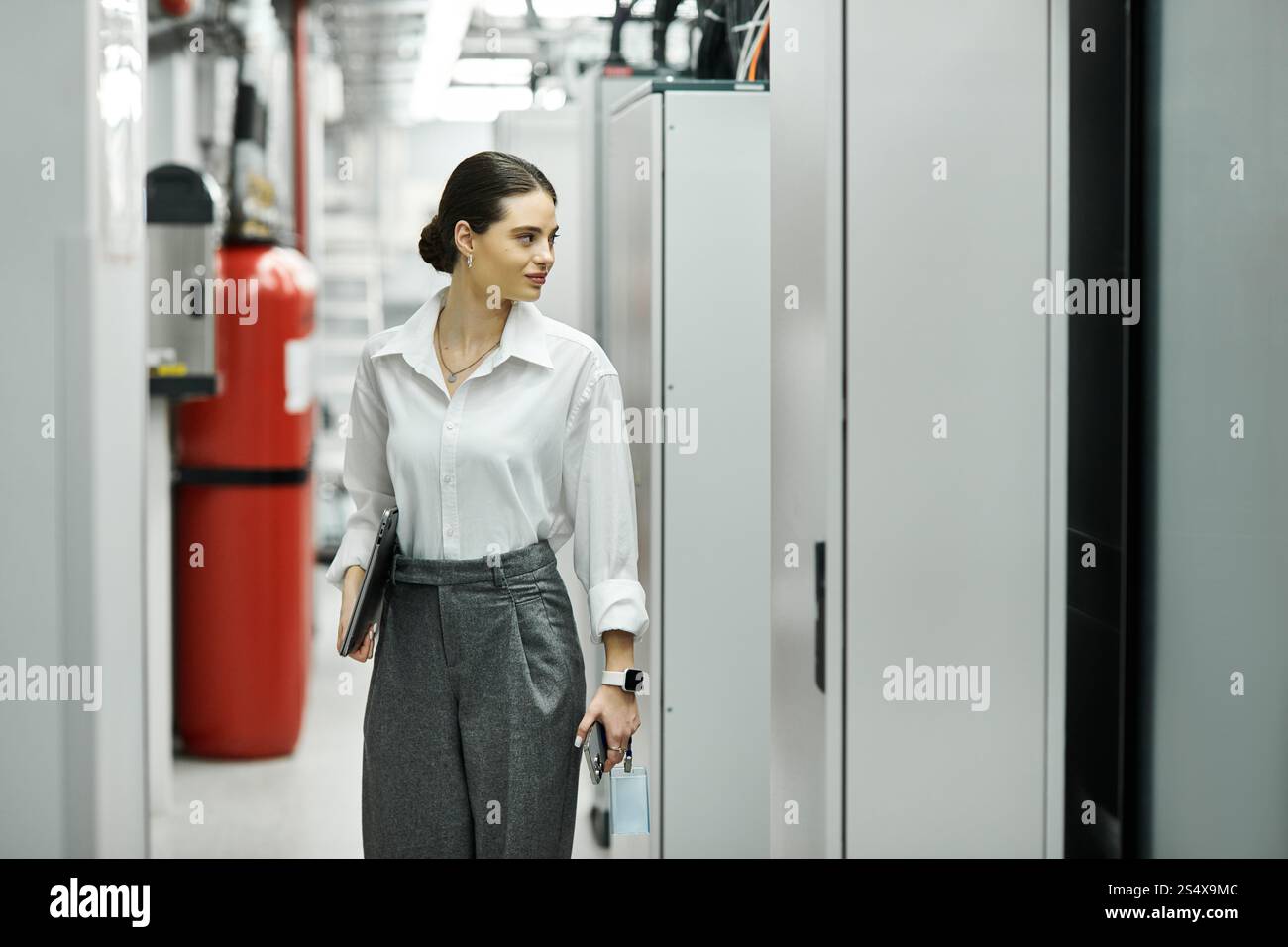 A professional woman works diligently in a contemporary server room ...
