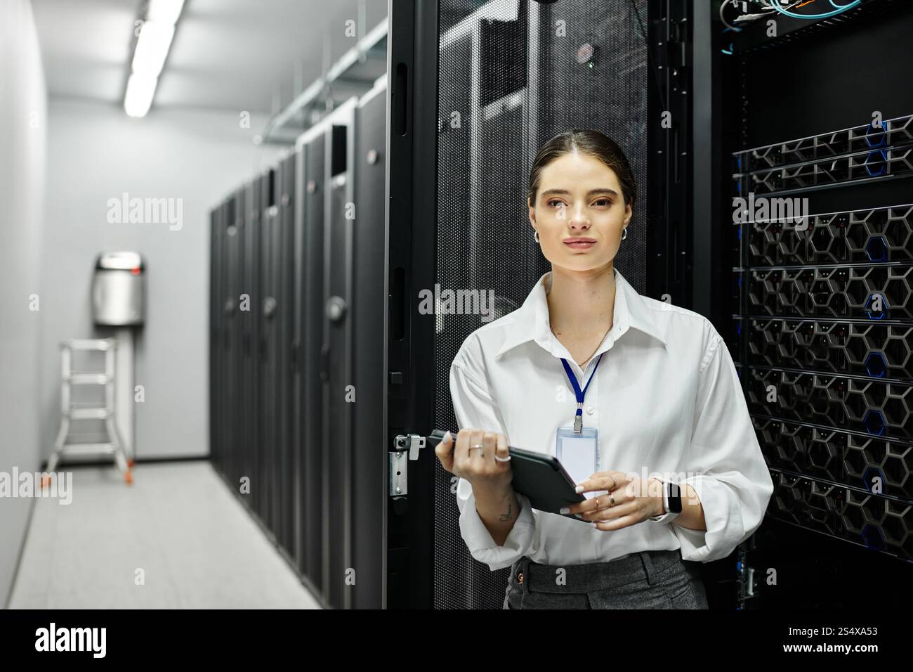 A woman in a white shirt efficiently oversees network systems in a ...