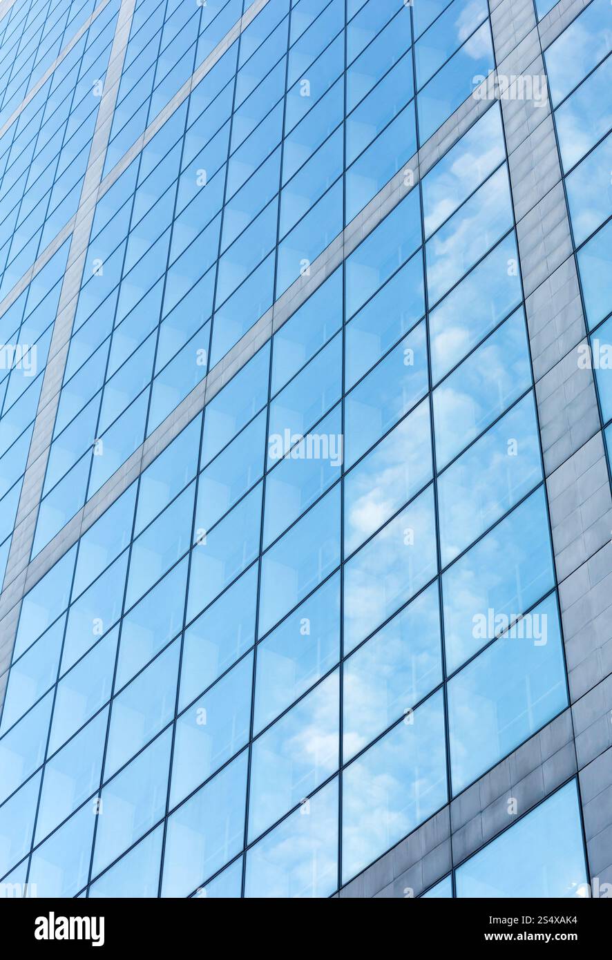 Wall of skyscraper with great number of windows and clouds reflection ...