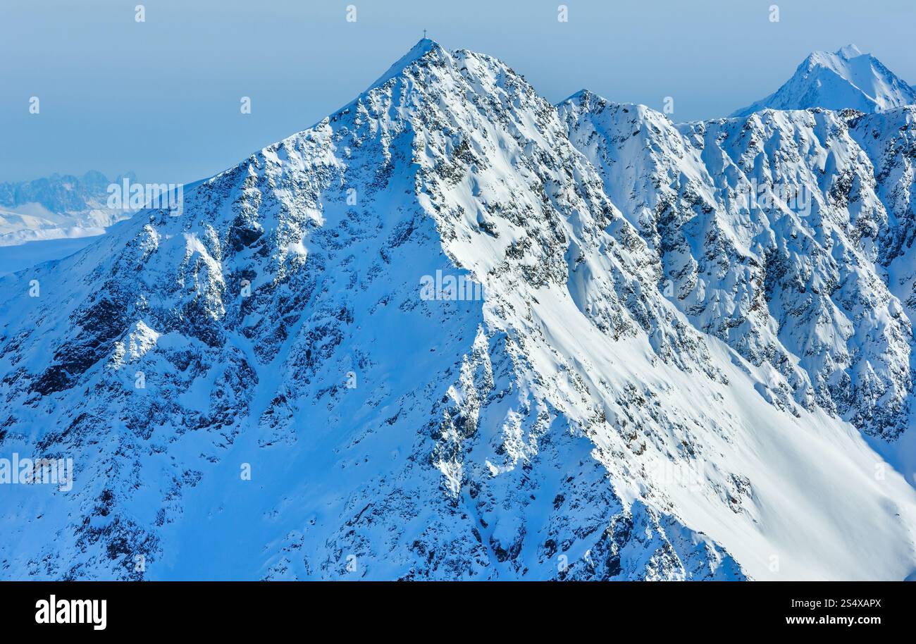 Cross on mount top. Scenery from the cabin ski lift at the snowy slopes ...
