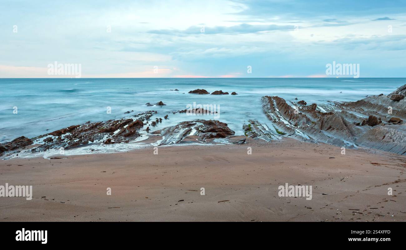 Twilight ocean coast with ribbed stratiform rock formations (Atlantic ...