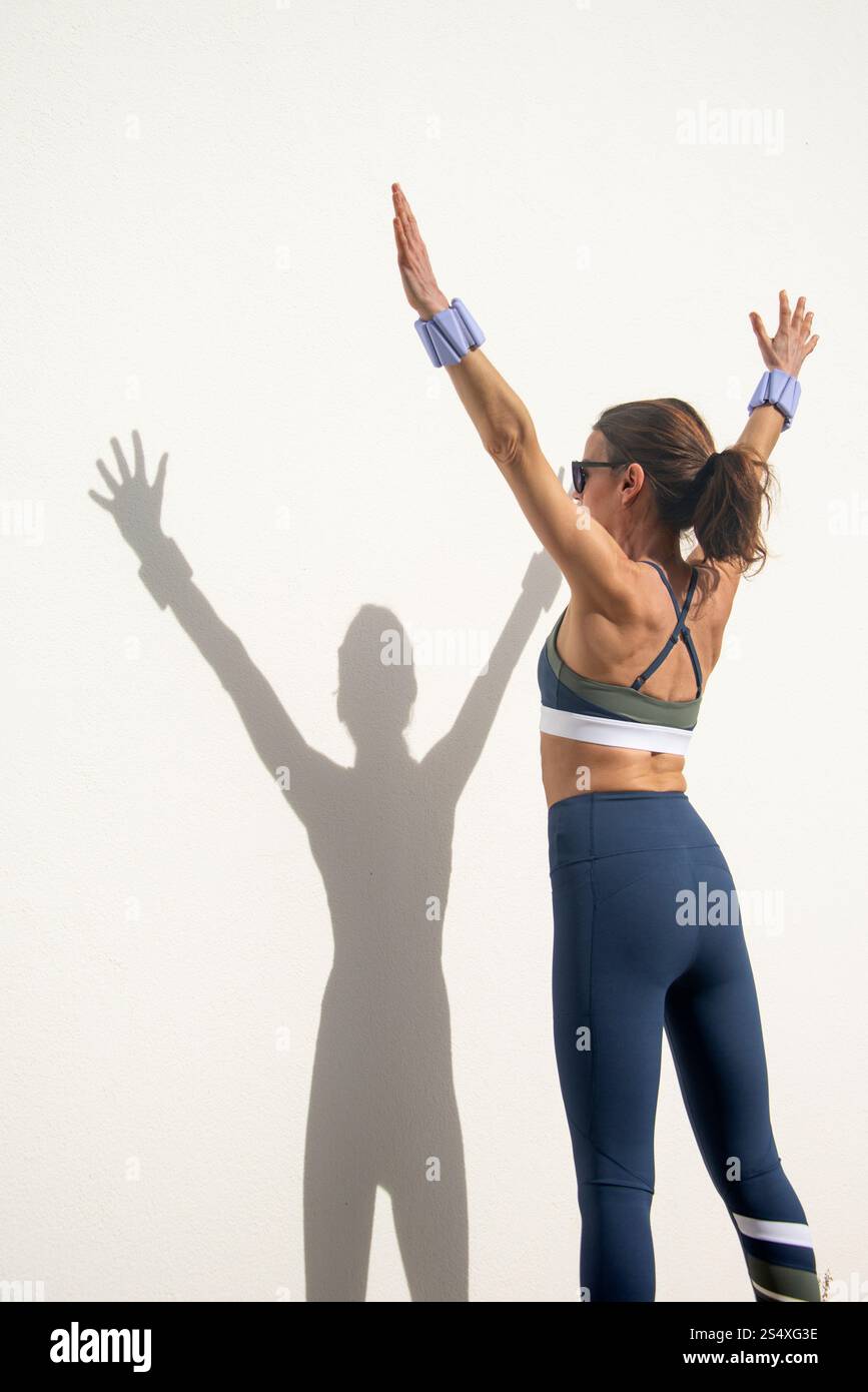 woman doing arm stretching exercises with adjustable wrist weights ...