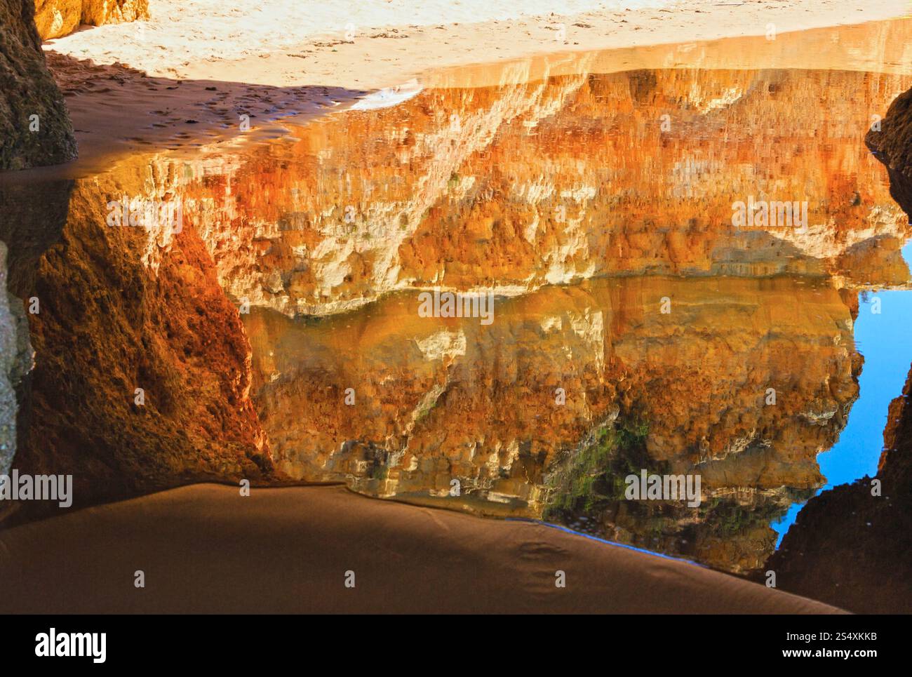 Reflection of yellow rocks in sea water near sandy beach (Dos Tres ...