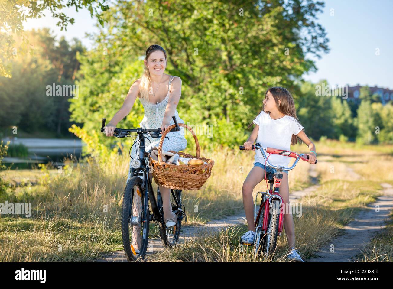 Beautiful young mother cycling with daughter riding to picnic Stock ...