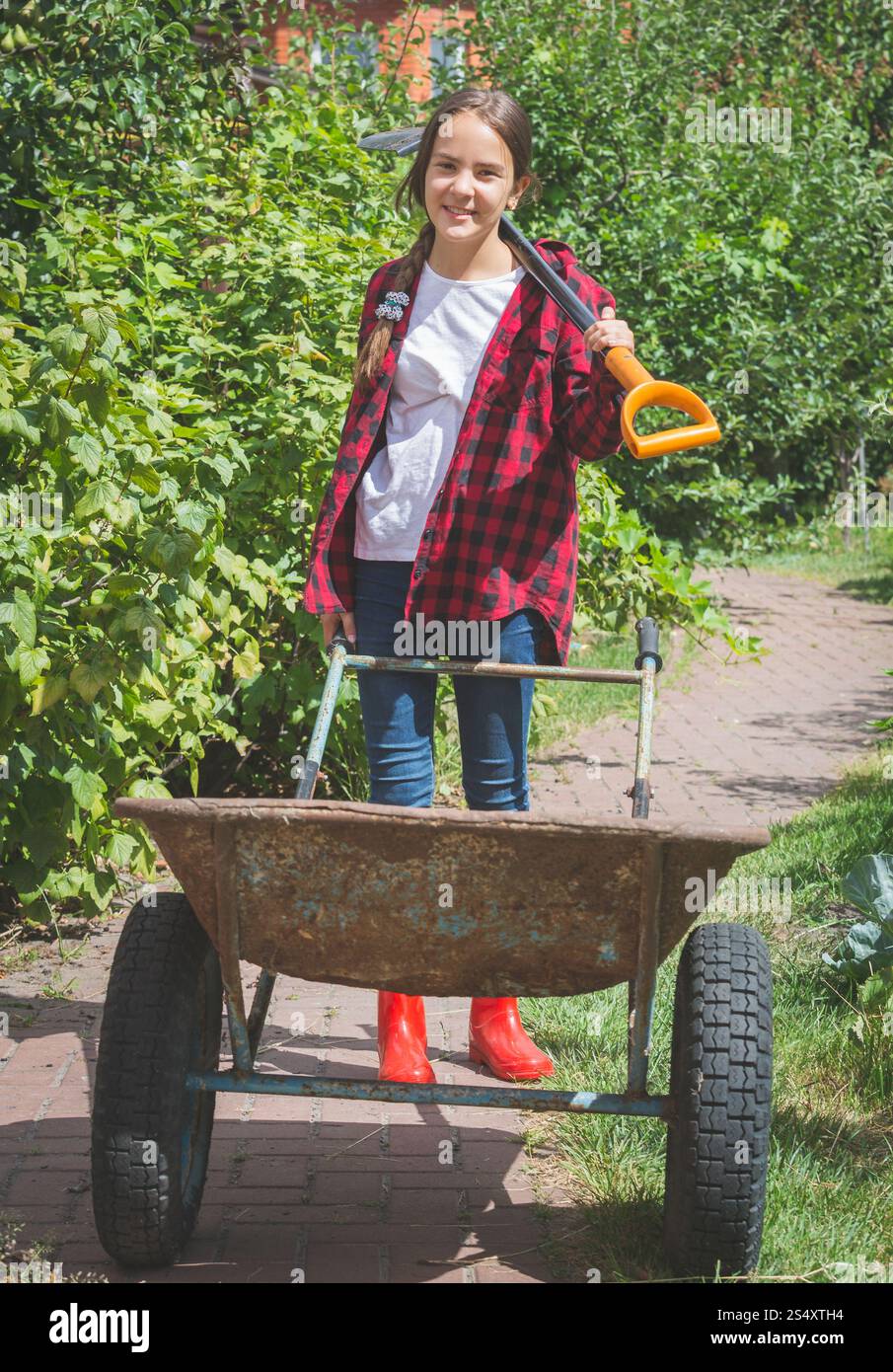 Beautiful smiling teen girl in wellies working in garden Stock Photo ...