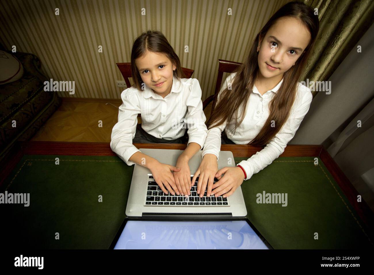 Portrait of two teen girls using laptop at cabinet Stock Photo - Alamy