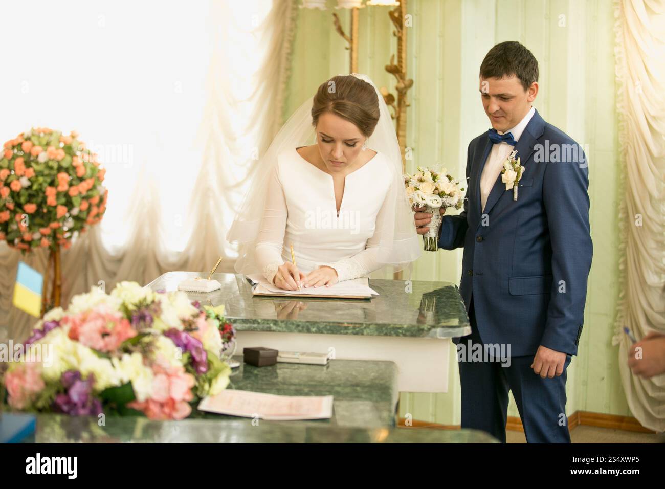 Portrait of beautiful young bride signing wedding license at registry ...
