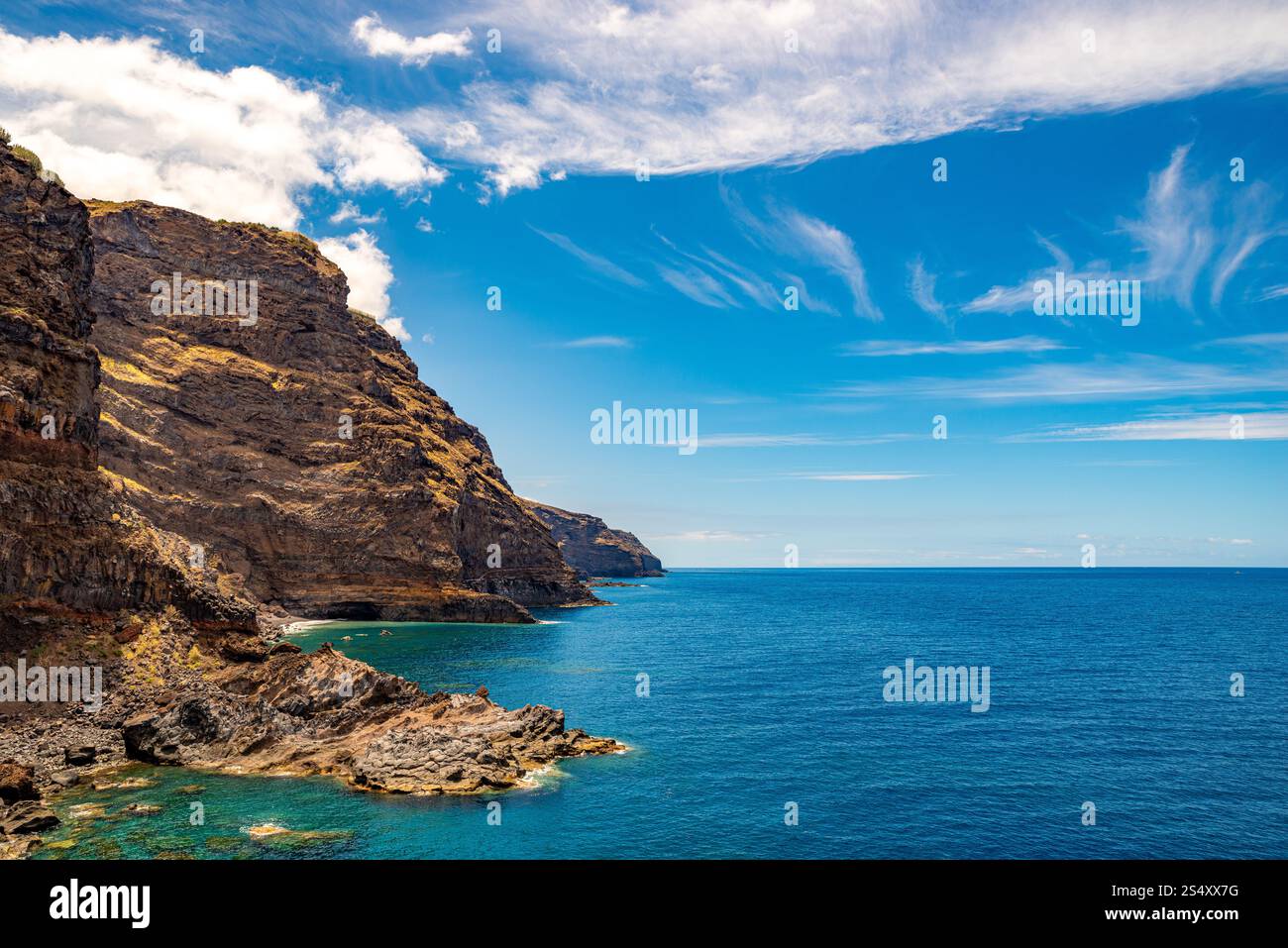 The rugged west coast of Cayado Nuevo and the blue, calm Atlantic Ocean ...