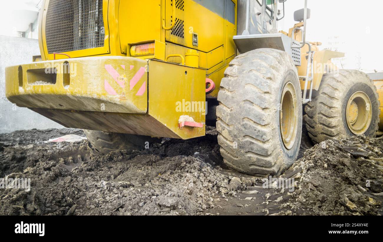 Big yellow bulldozer covered in dirt working on ground Stock Photo - Alamy