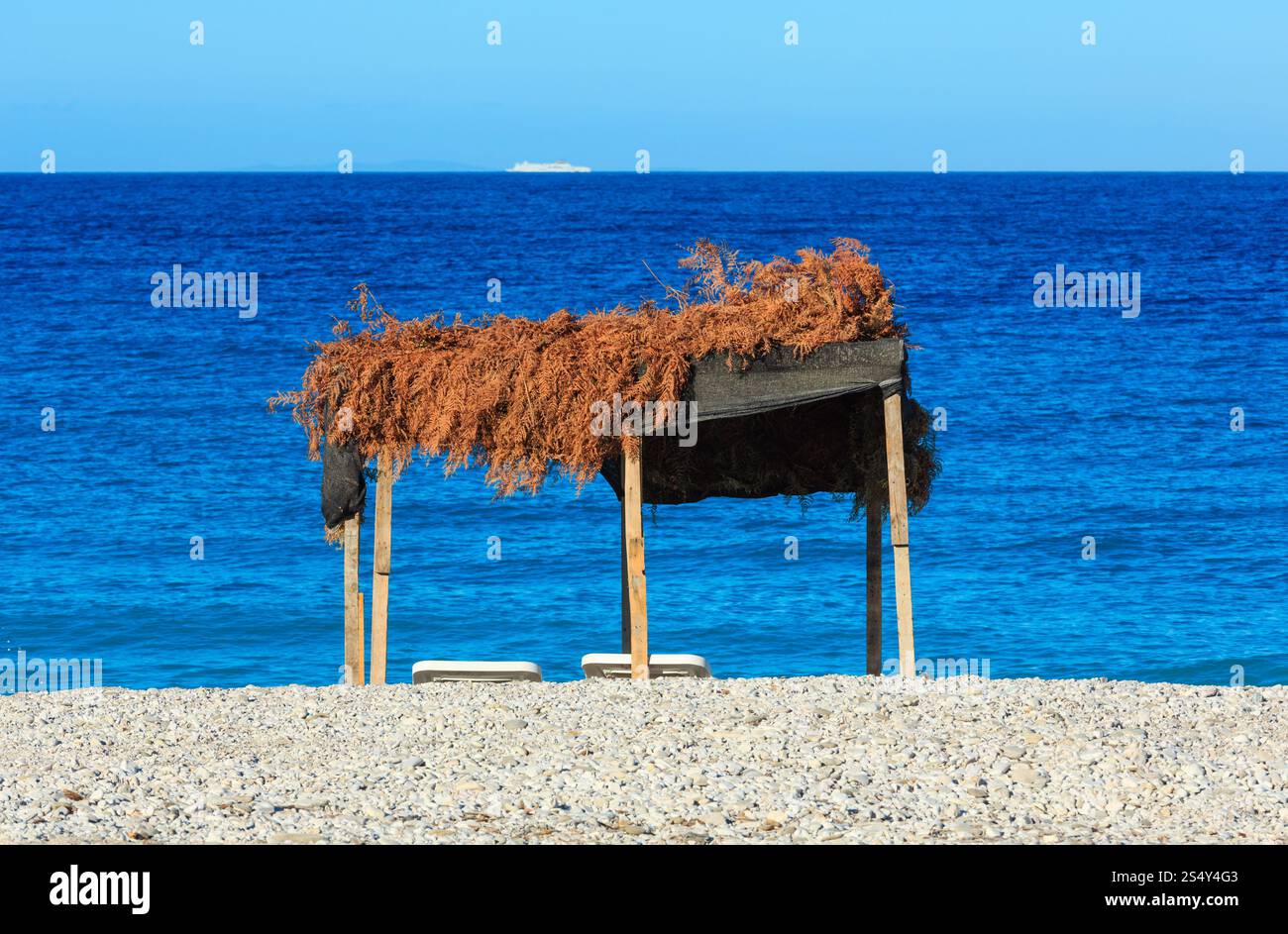 Summer morning beach with sunbeds, canopy and white pebble (Albania ...