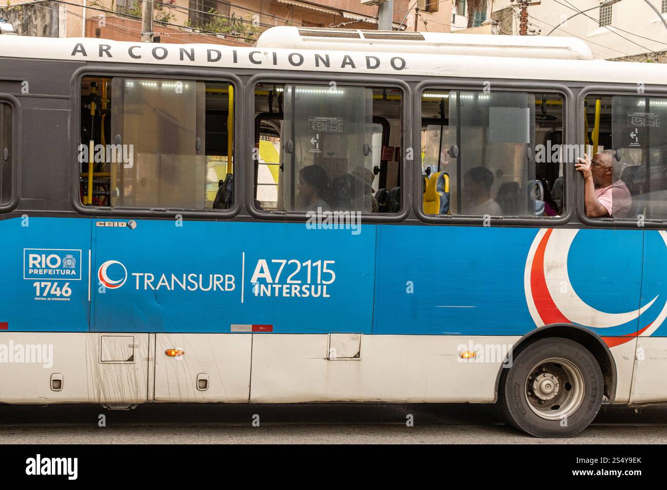 A man rides a local bus with his arm out of the window in Santa Teresa ...