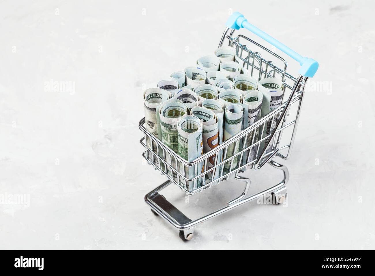 shopping cart with rolls from dollar banknotes on concrete board Stock ...