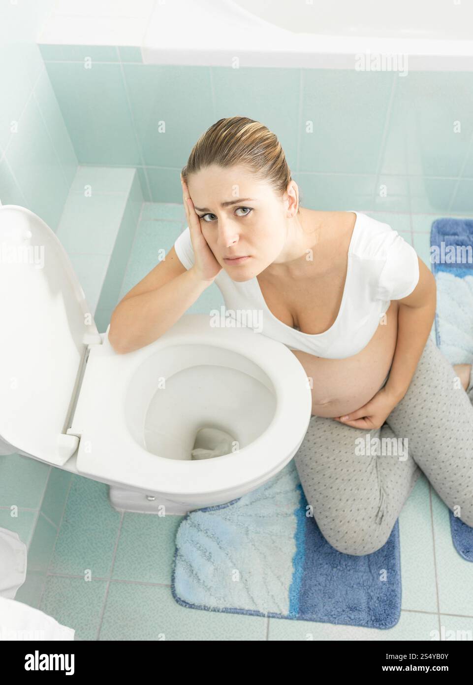 Portrait of young pregnant woman suffering from intoxication and ...