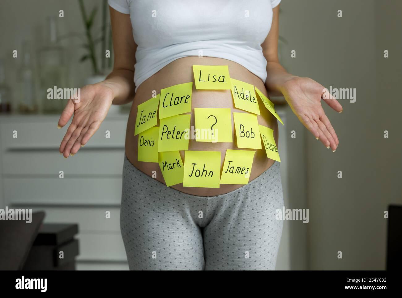 Closeup photo of pregnant woman with child names on belly Stock Photo ...