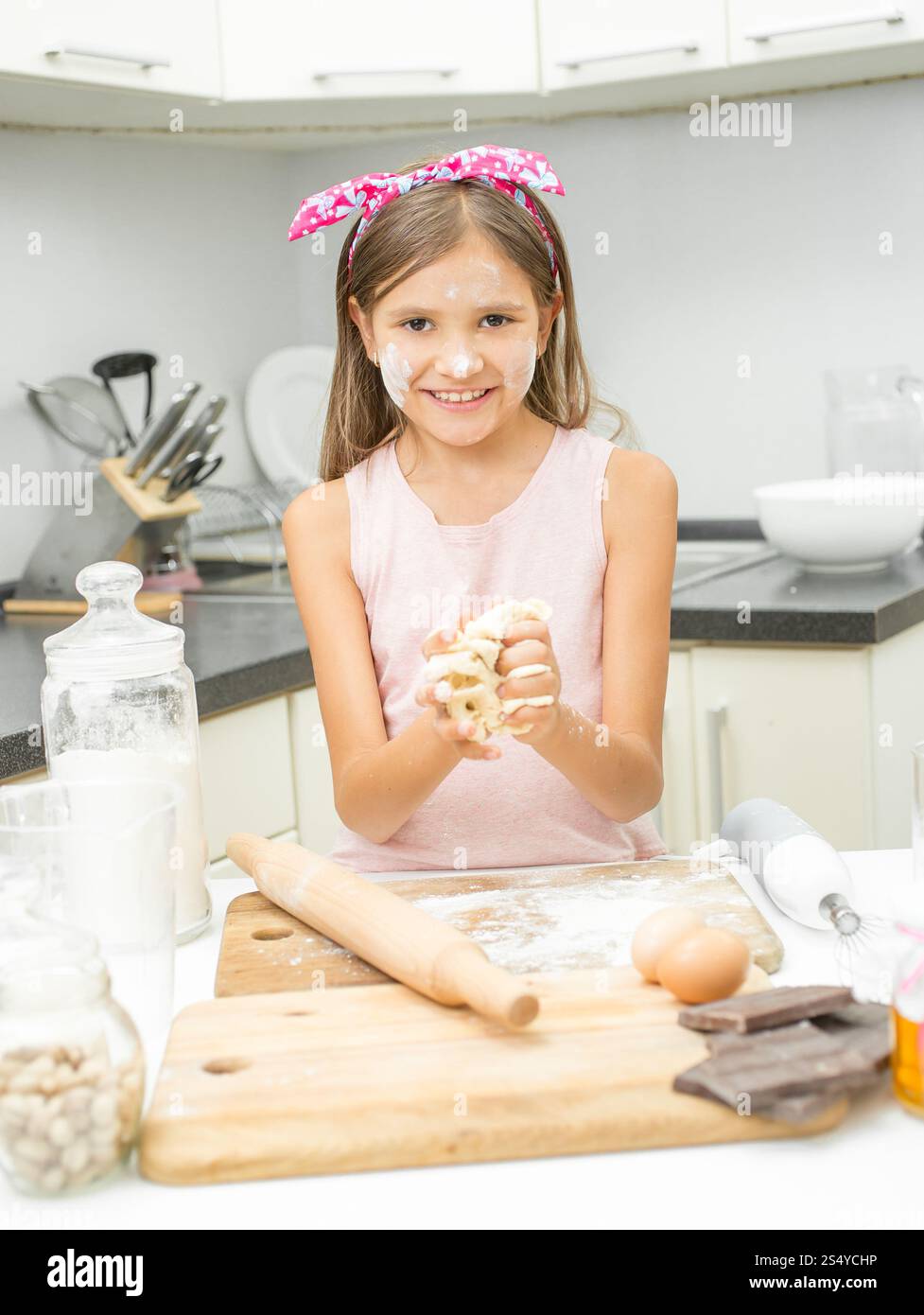 Portrait of happy smiling girl making dough for pie on kitchen Stock ...