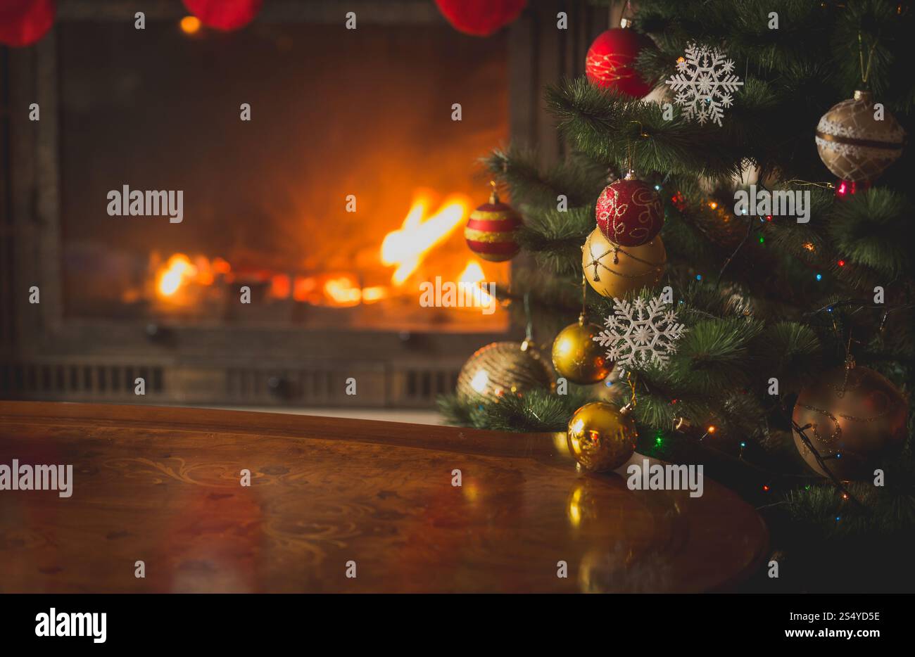 Closeup image of baubles on Christmas tree in front of burning ...