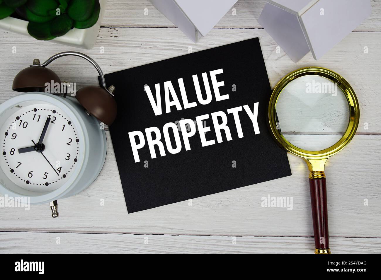 Value Property text message on sticky note with alarm clock, magnifying ...
