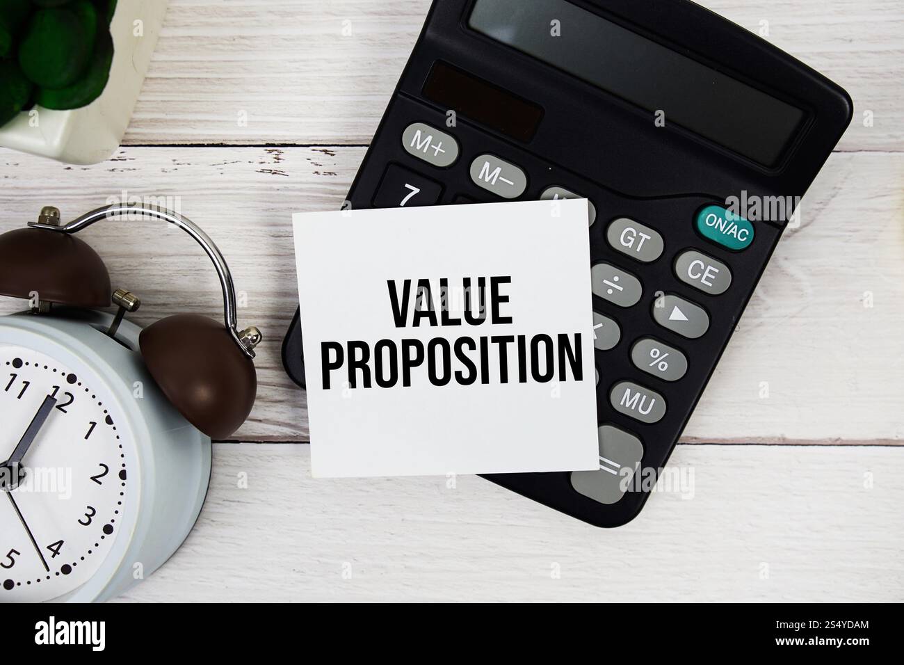 Value Proposition text on sticky note with alarm clock and calculator ...