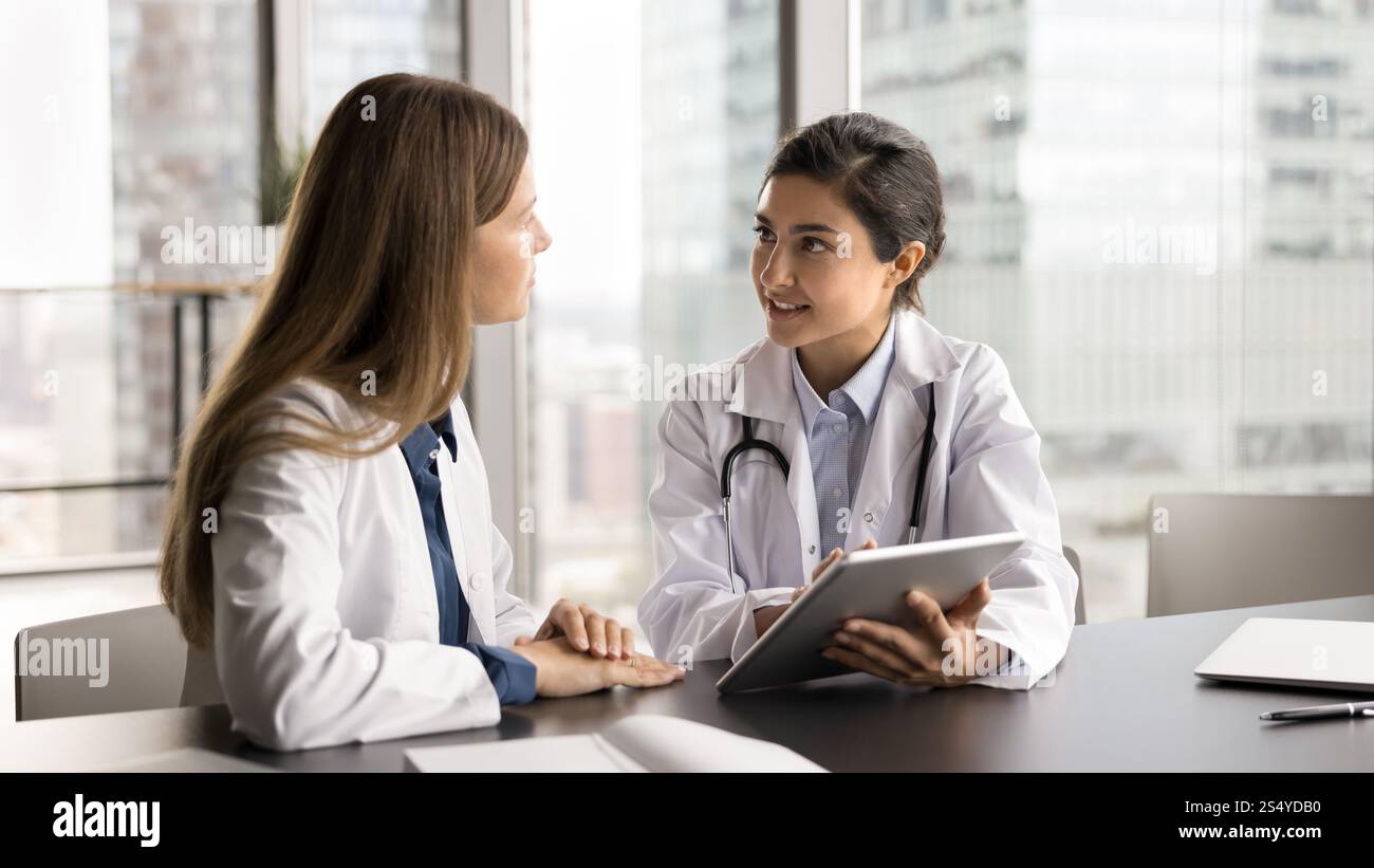 Two women physicians working on joint task in clinic office Stock Photo ...