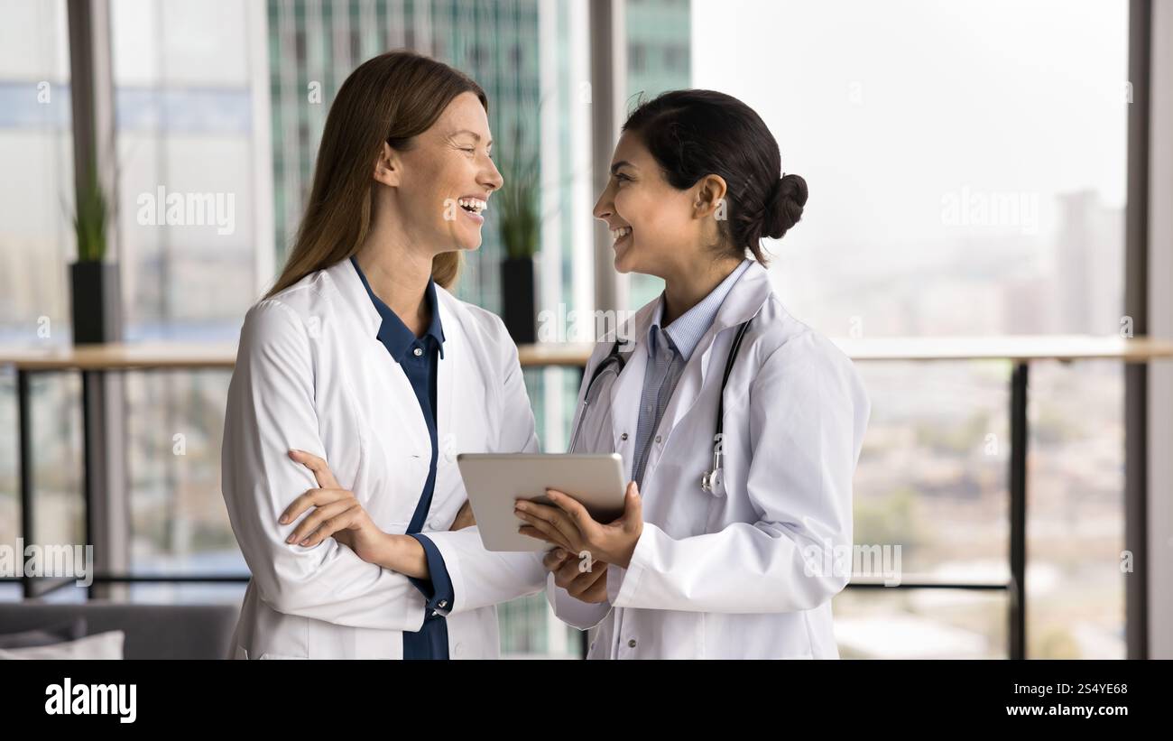 Two doctors laughing while lead informal conversation during break ...