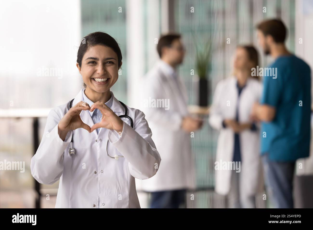 Female doctor showing heart shape with joined fingers Stock Photo - Alamy
