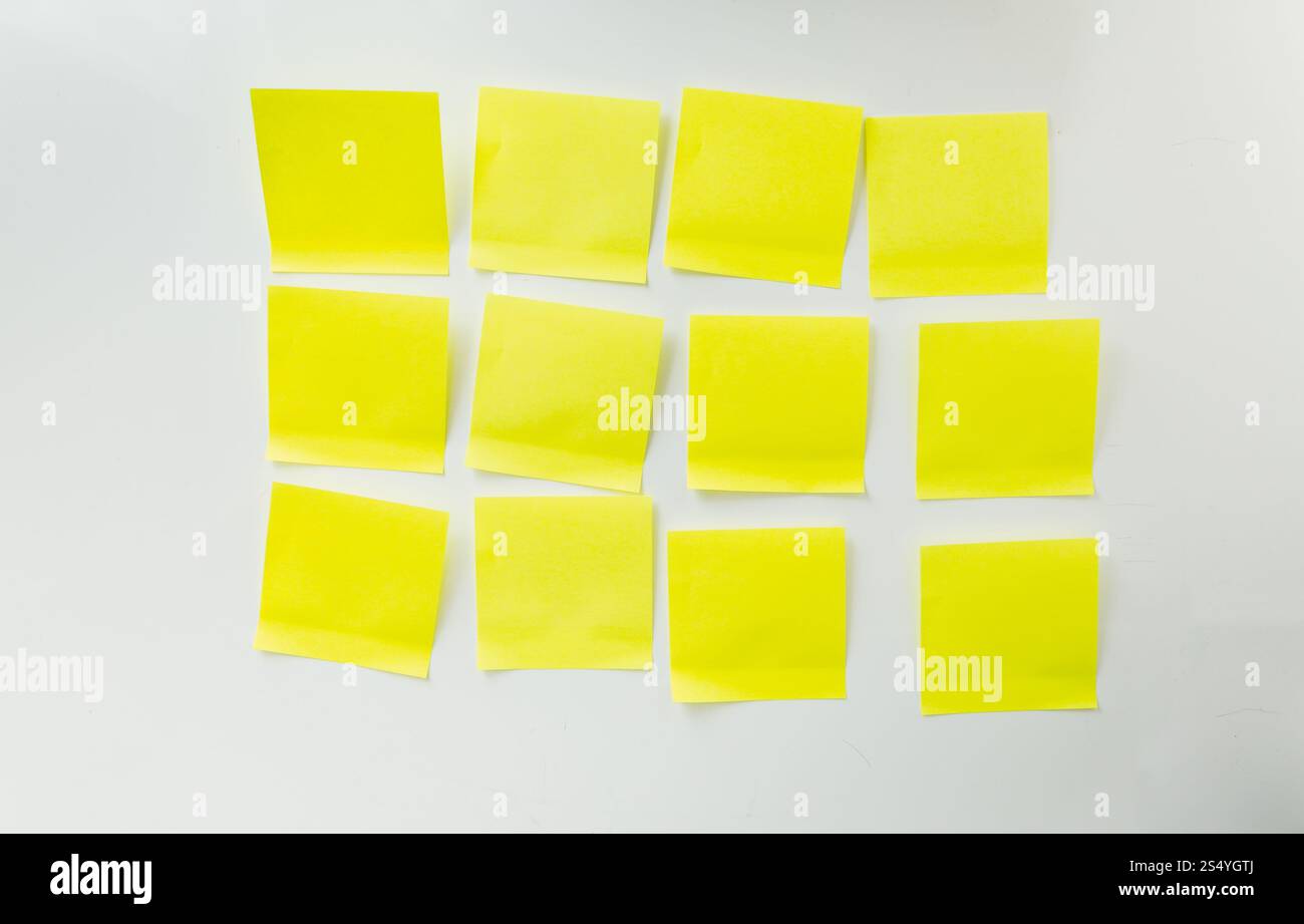 12 blank yellow sticky notes on white board Stock Photo - Alamy