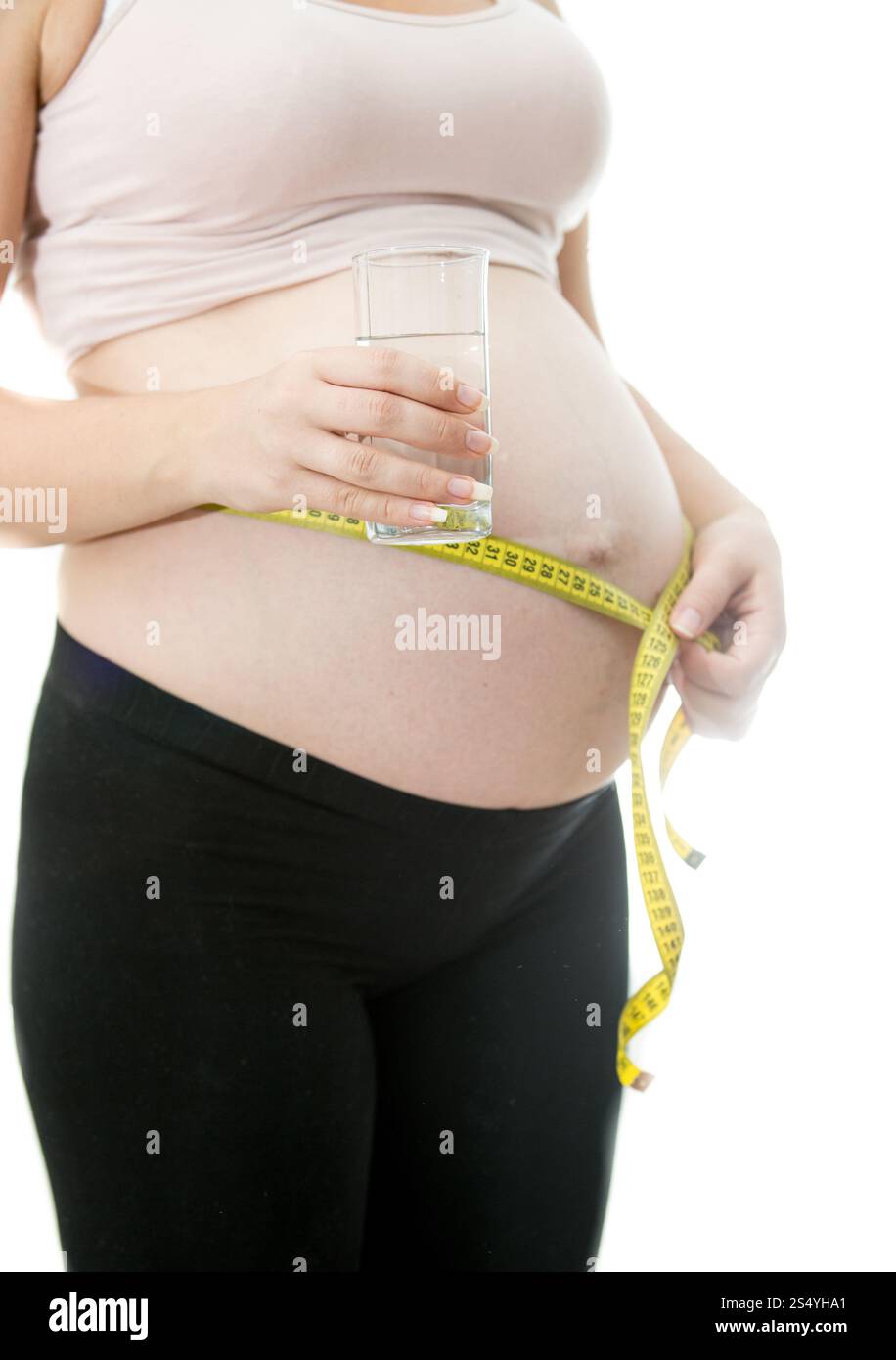 Closeup photo of young pregnant woman holding glass of water and ...