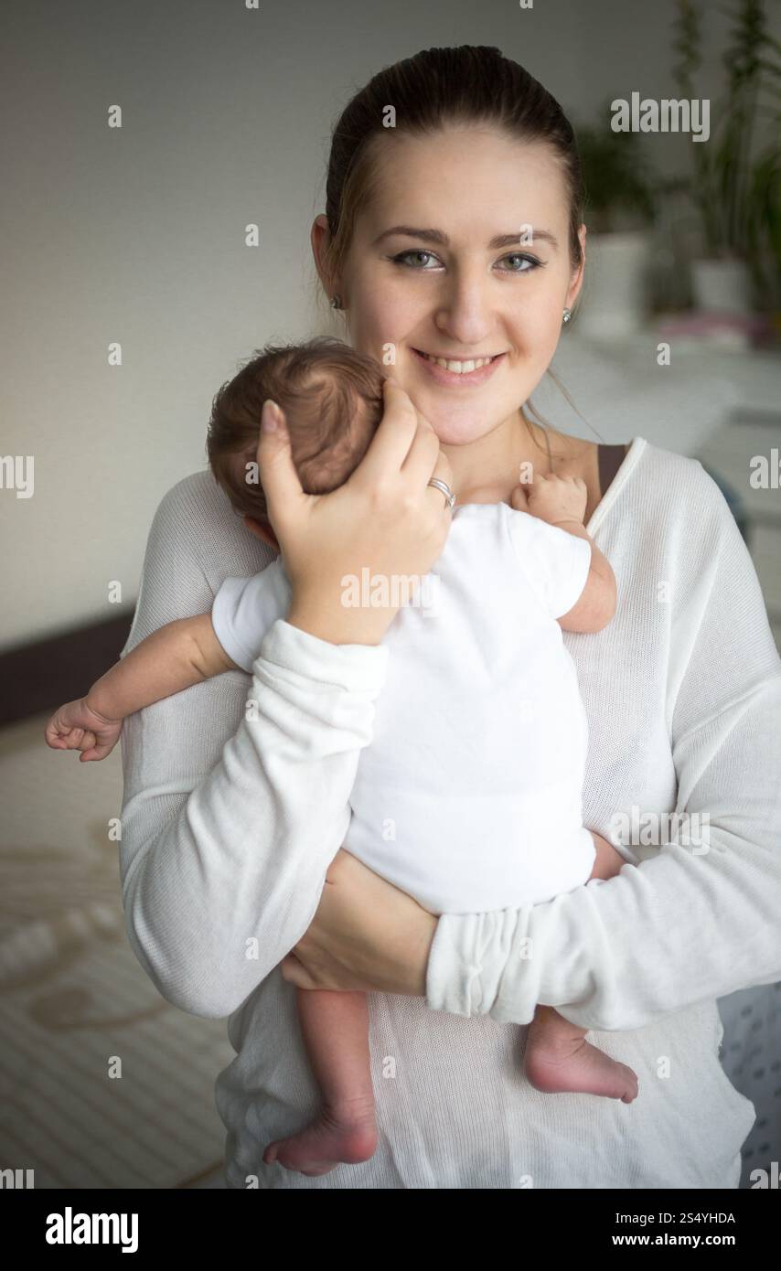 Portrait of smiling caring mother holding cute baby boy on hands Stock Photo - Alamy
