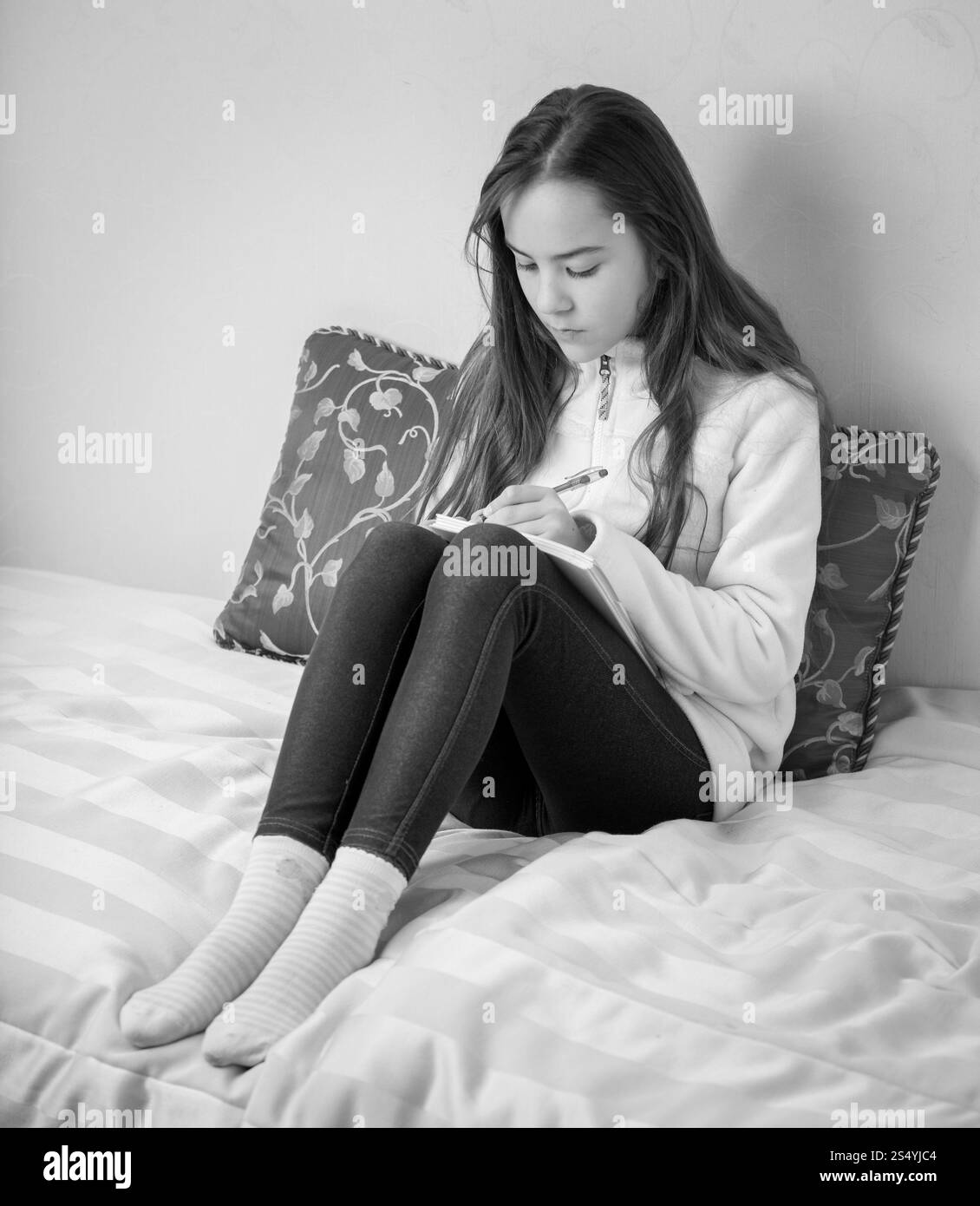 Black and white portrait of teenage girl making notes in diary at ...
