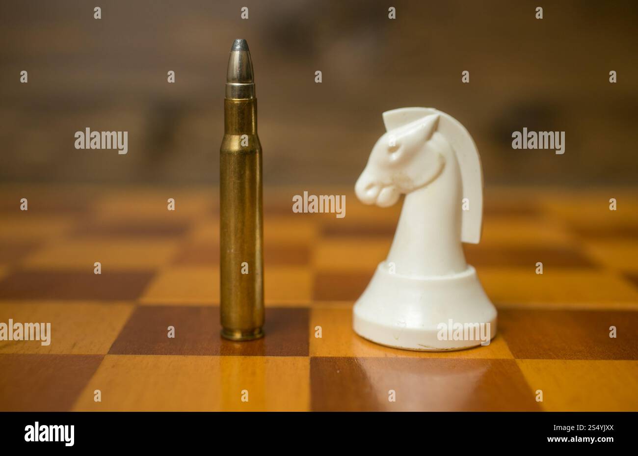 Closeup photo of bullet standing on chessboard with another chess piece ...