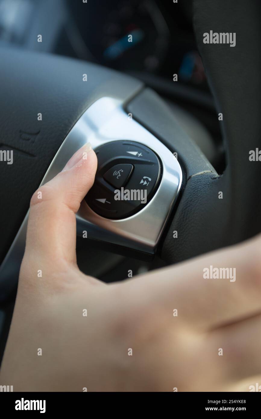 Closeup of driver using control panel on steering wheel Stock Photo - Alamy
