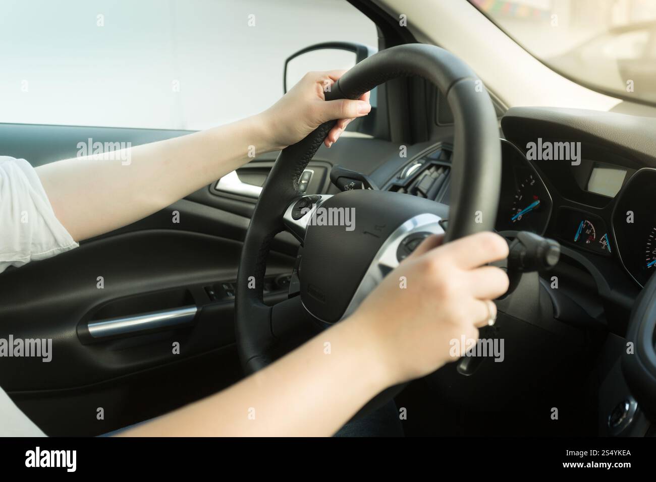 Young woman driving car and holding hands on steering wheel Stock Photo ...